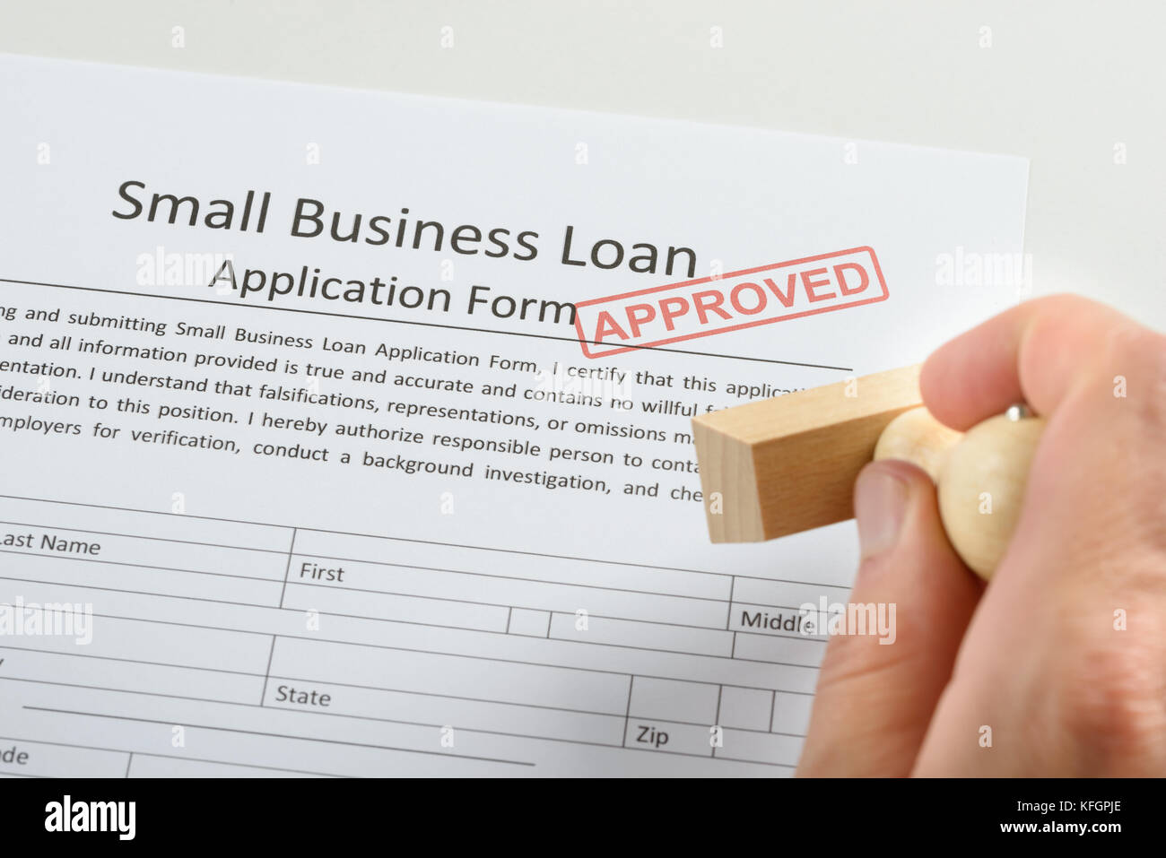 Close-up Of Person Hand Holding Approved Rubber Stamp Over Loan ...