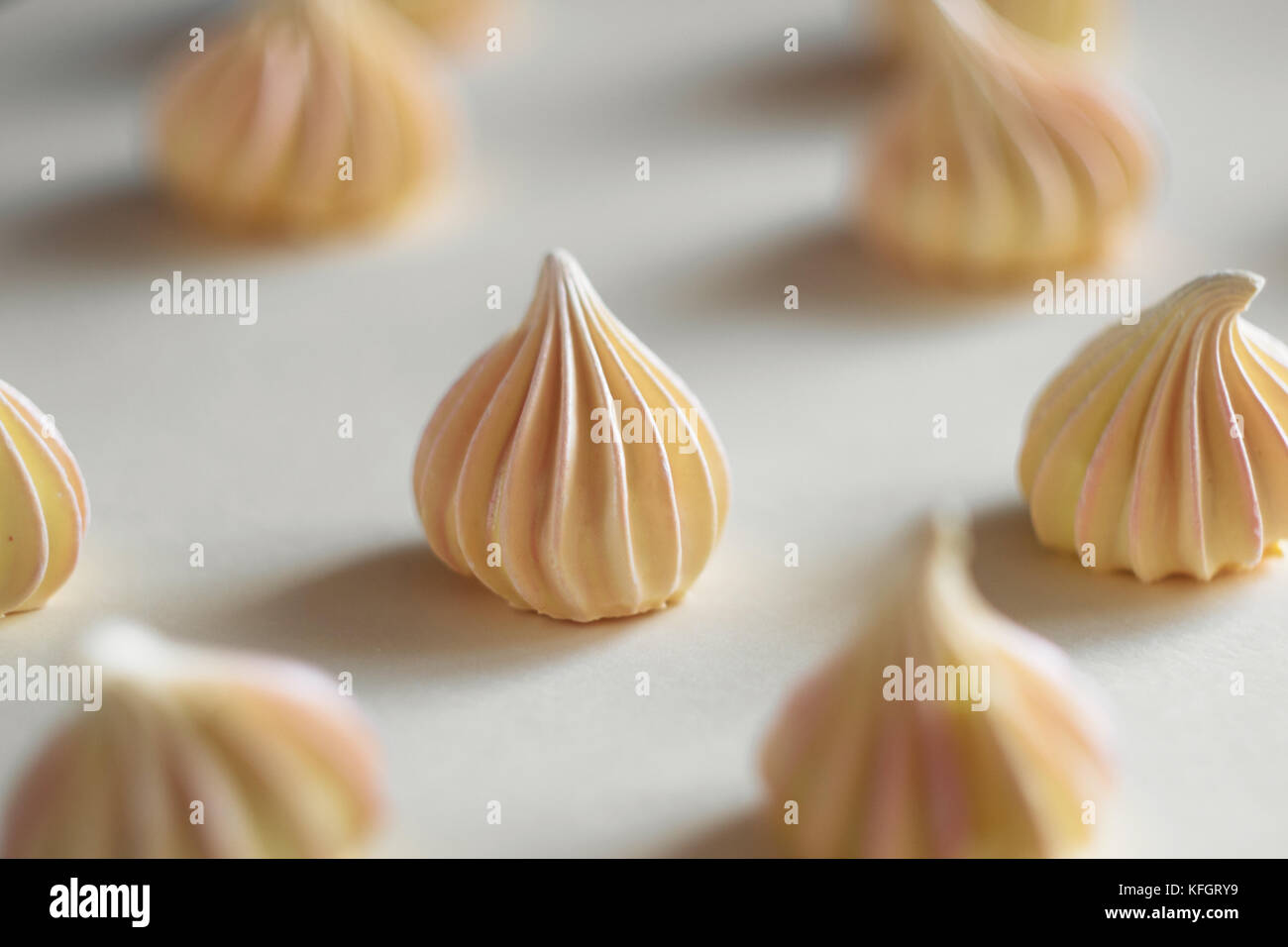 Many yellow Meringue, on white background Stock Photo - Alamy