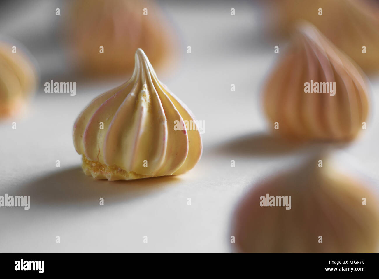 Many yellow Meringue, on white background Stock Photo - Alamy