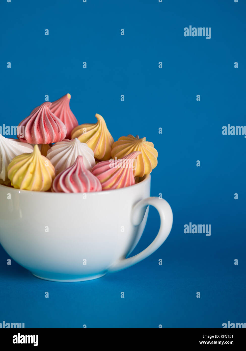 Dessert with meringue, a lot of colorful meringues in the tea Cup Stock ...