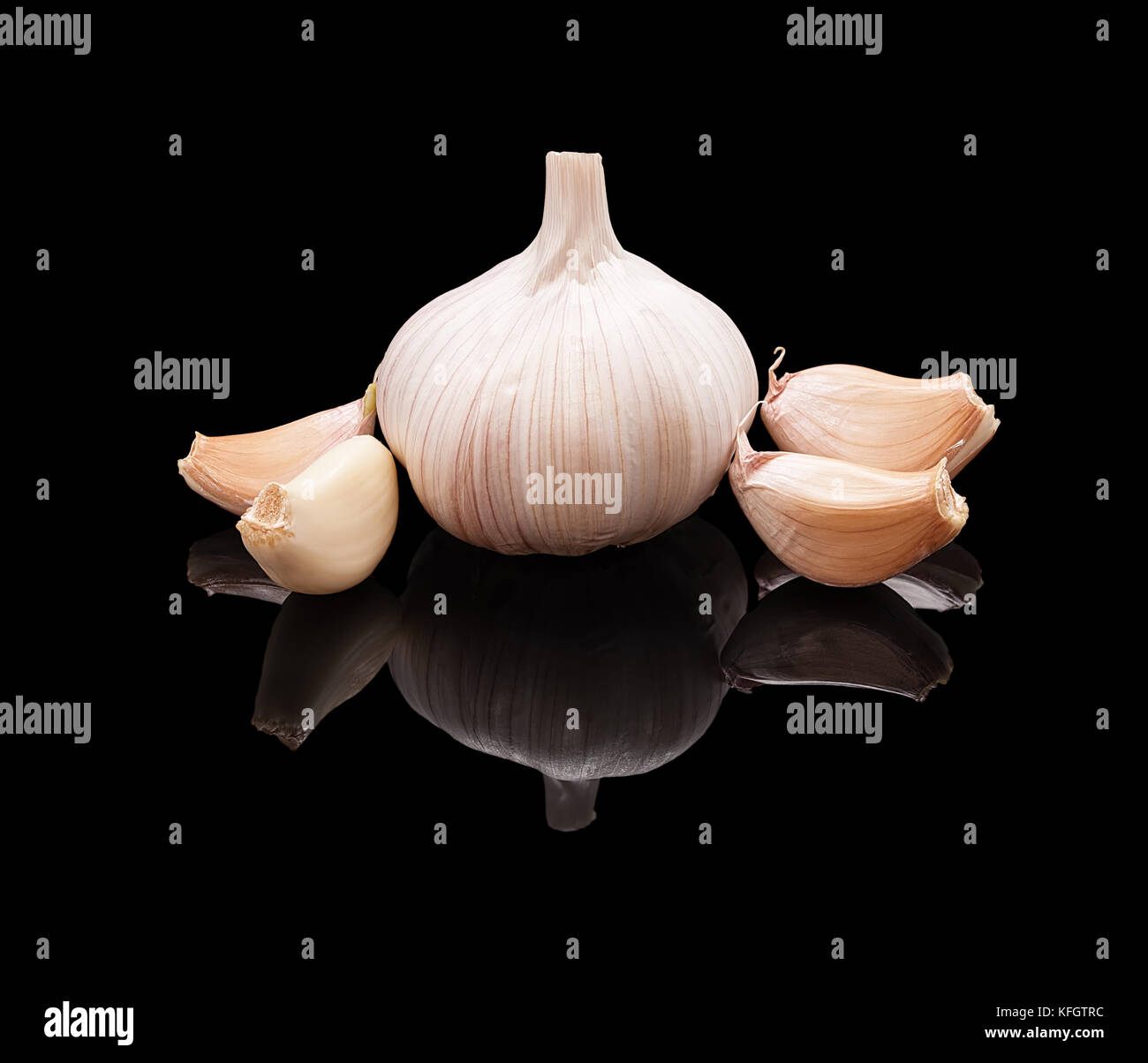 One unpeeled garlic with clove isolated on black glossy background with ...