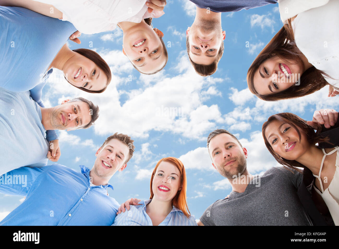Directly below portrait of happy multiethnic friends forming huddle ...