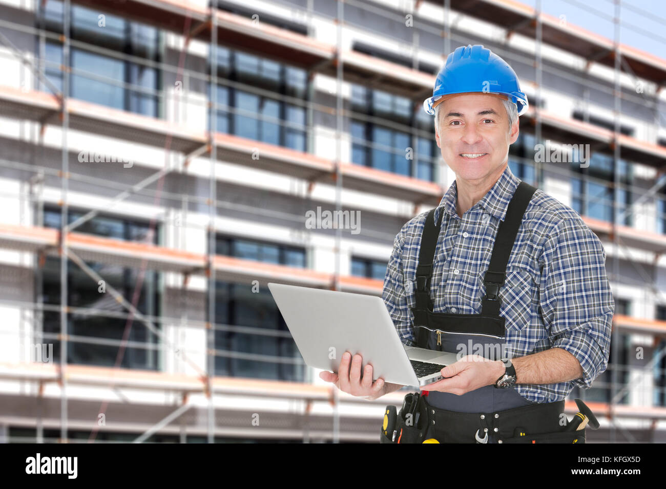 Portrait of senior architect using laptop against building Stock Photo ...