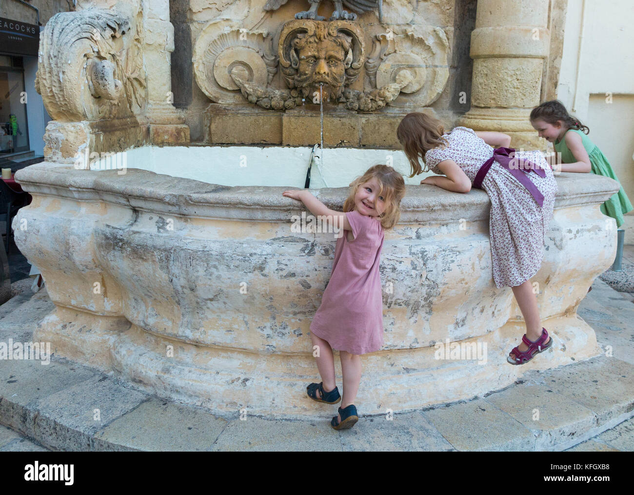 Children play around water feature / waterfall / water fountain in ...