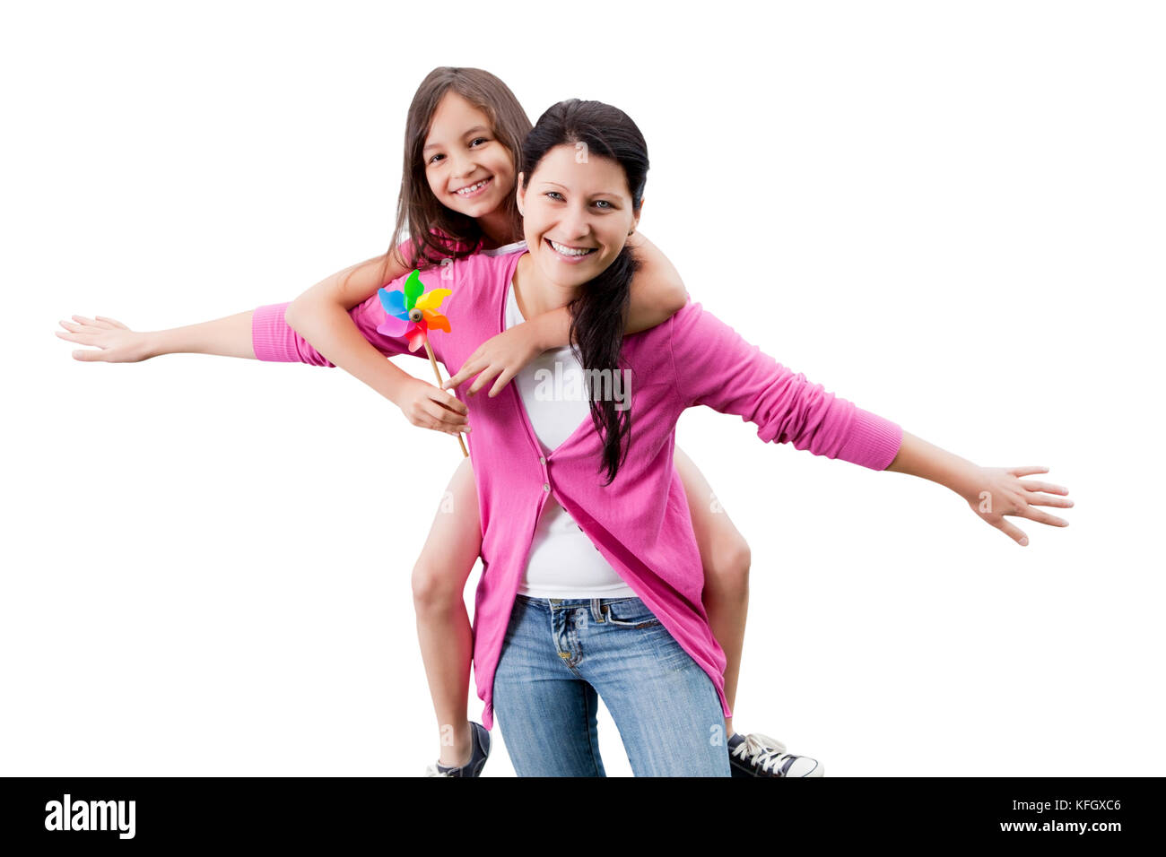 Portrait of happy woman piggybacking daughter against white background ...