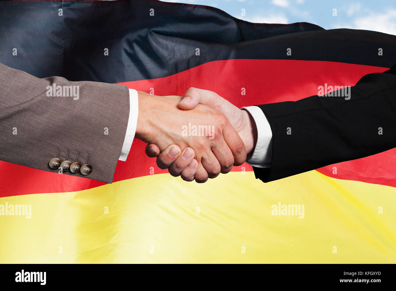 Close-up Of Two Businesspeople Shaking Hands In Front Of German Flag ...