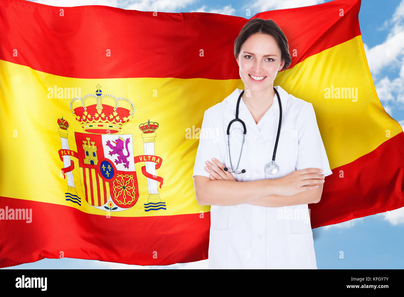 Young Female Doctor With Arm Crossed Standing In Front Of Spanish Flag ...