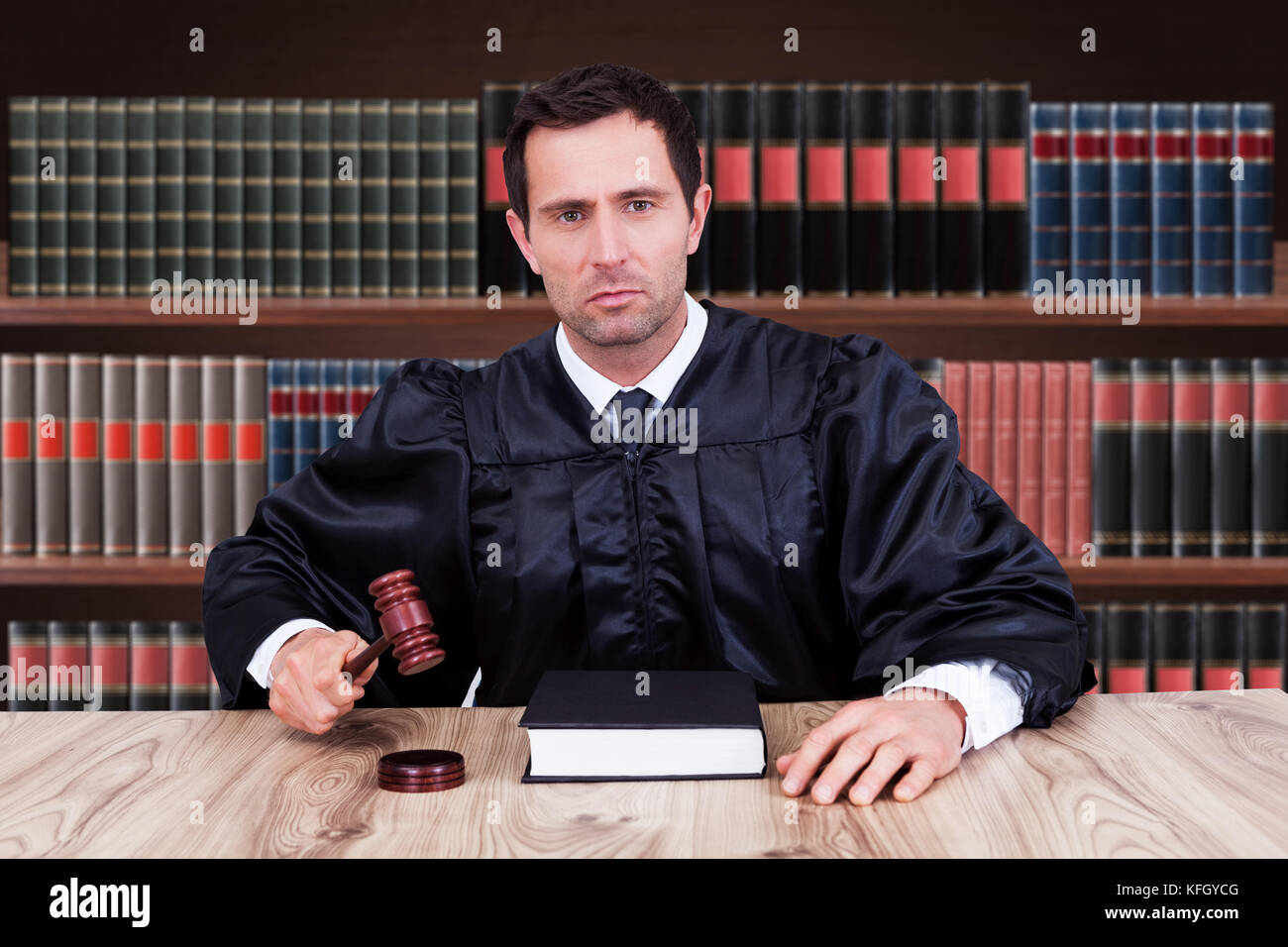 Portrait Of Serious Male Judge Striking Gavel In Courtroom Stock Photo ...