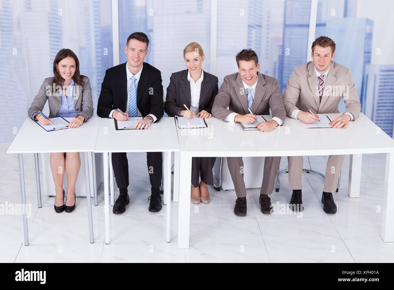 Panel of corporate personnel officers sitting at table for taking ...