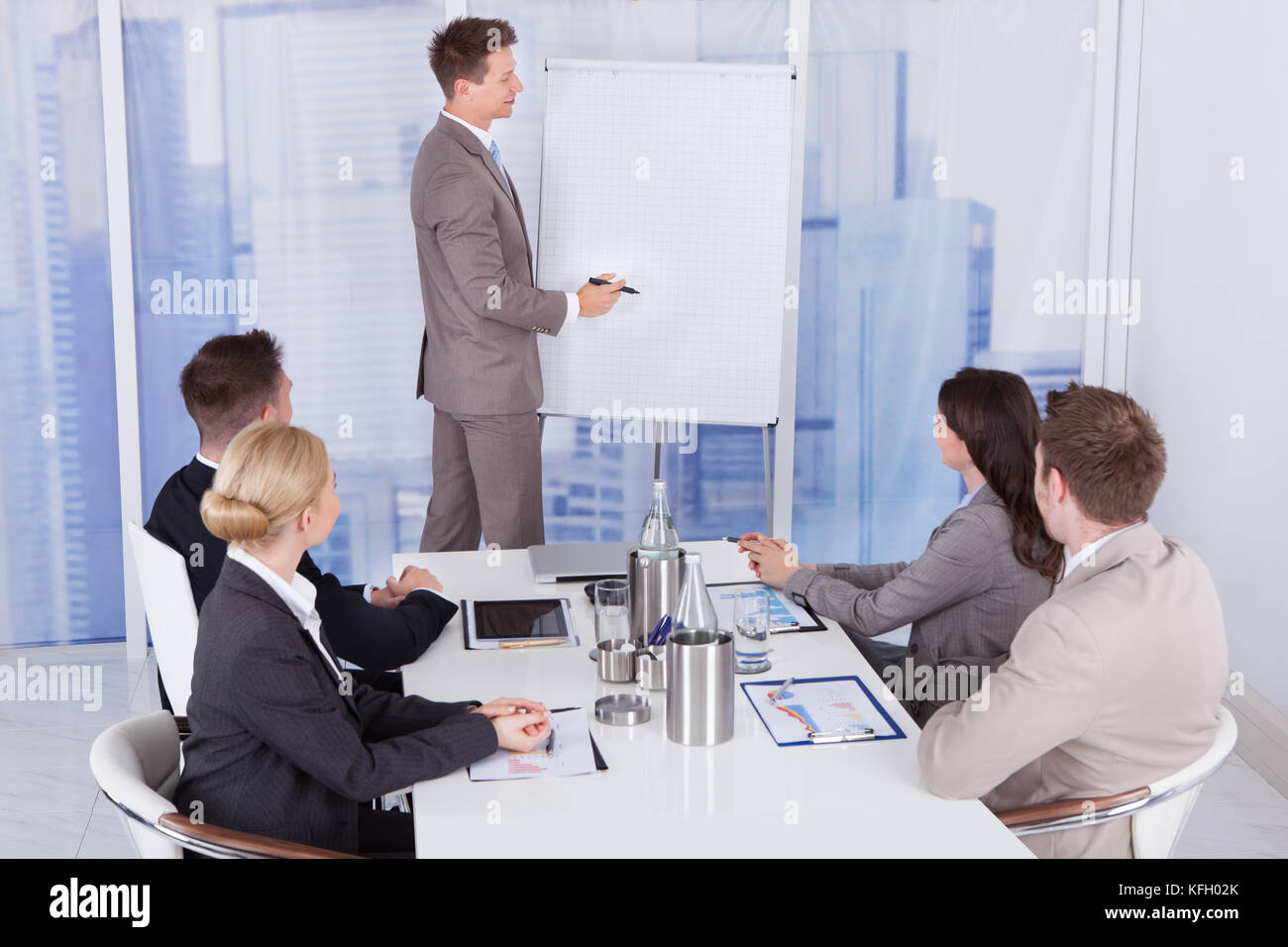 Young businessman giving presentation to colleagues at office Stock ...