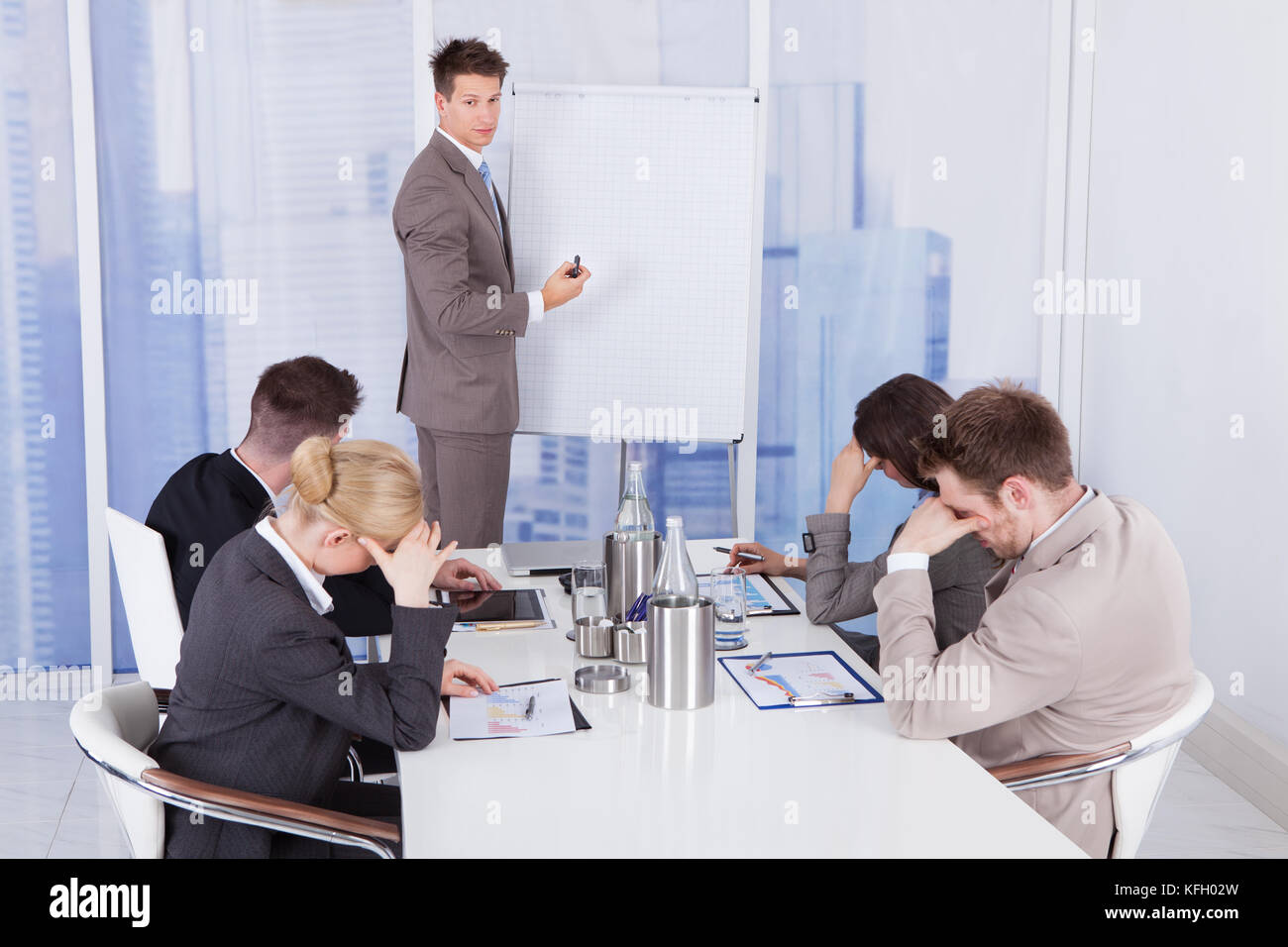 Colleagues getting bored during business presentation given by ...