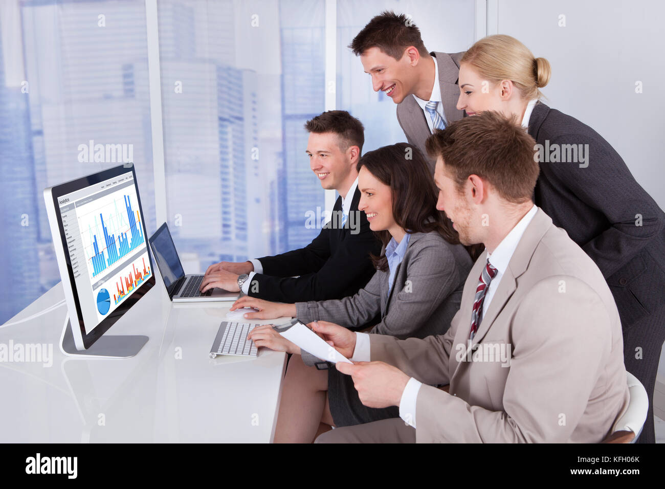 Group of young business people using computer and laptop in office ...