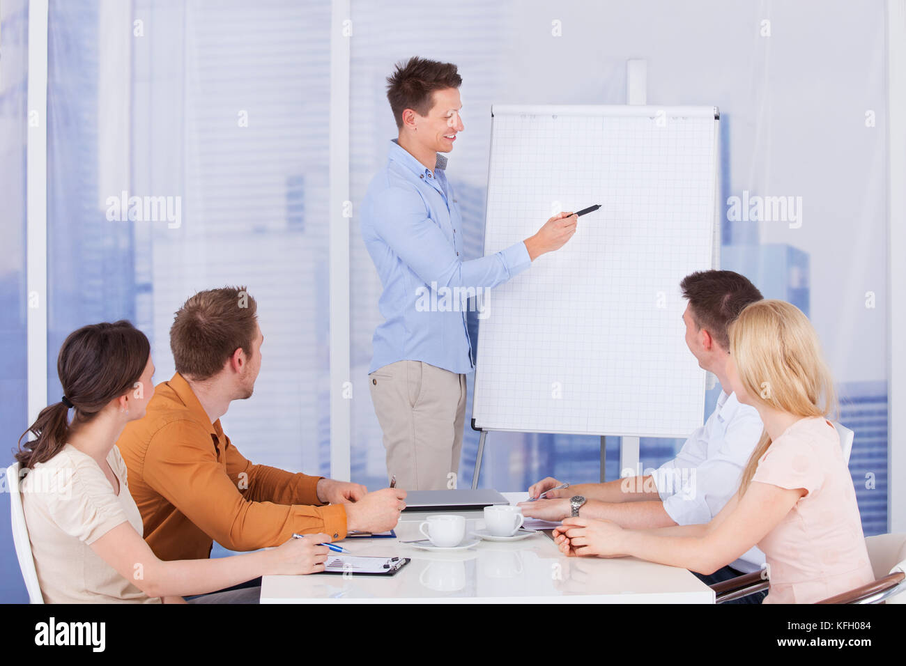 Young businessman giving presentation to colleagues in office Stock ...
