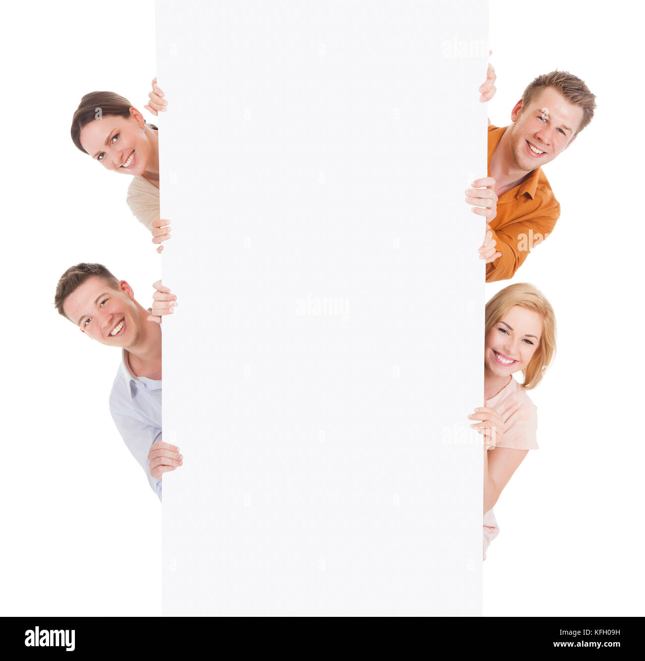 Portrait of smiling young friends looking from behind the blank ...