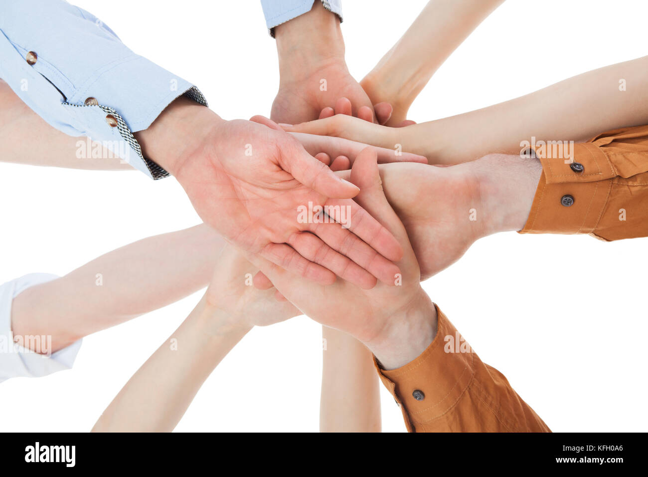 Closeup of young friends with their hands stacked together on white ...