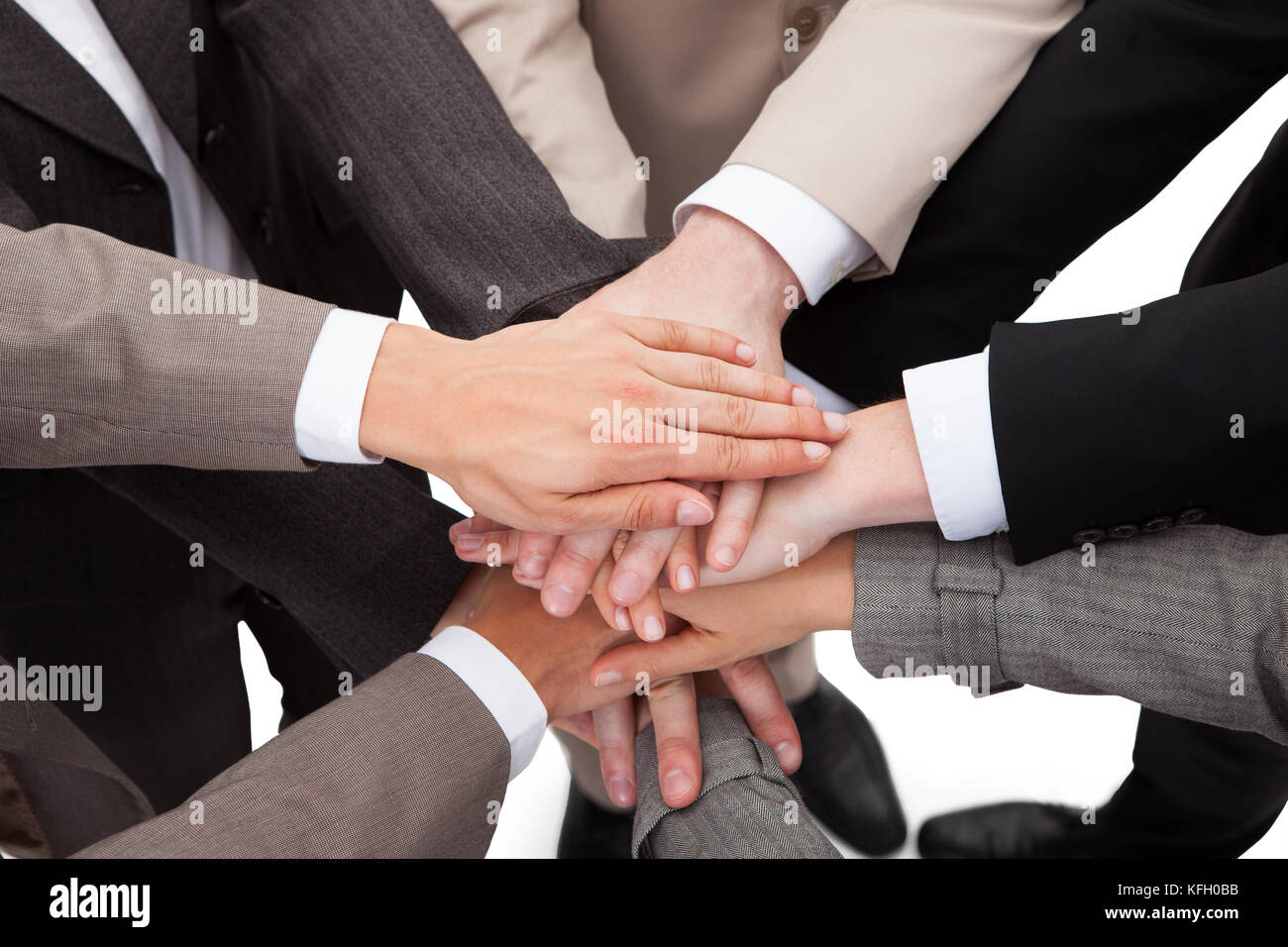 High angle view of business people stacking hands against white ...