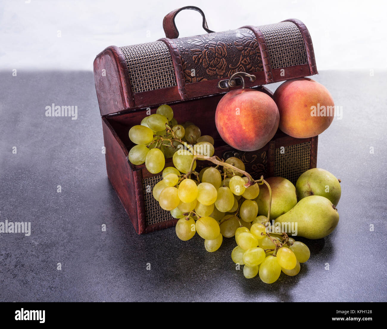 Oriental chest full of fruit like grapes pears peaches Stock Photo - Alamy