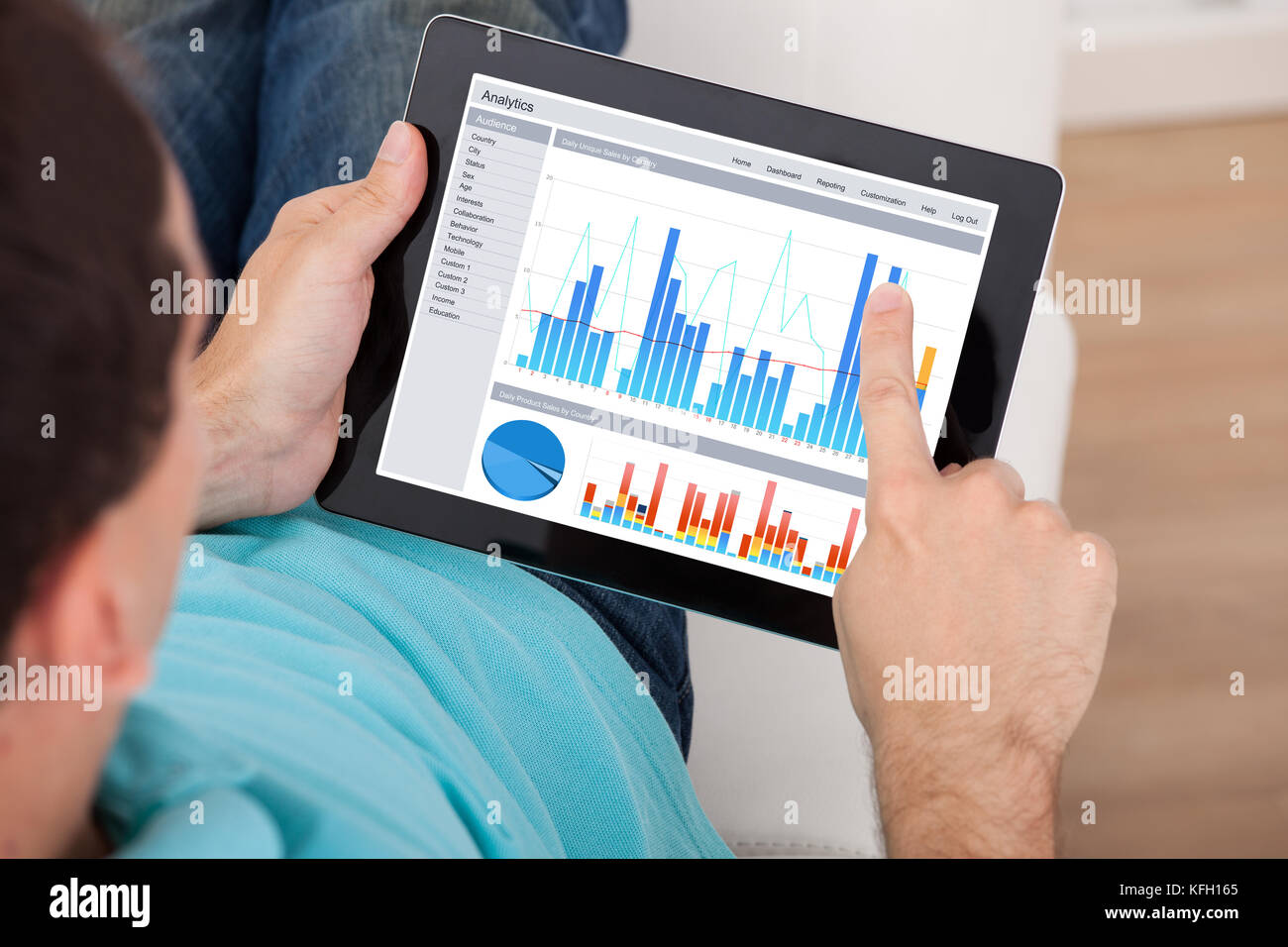 Cropped image of man analyzing graphs on digital tablet at home Stock ...