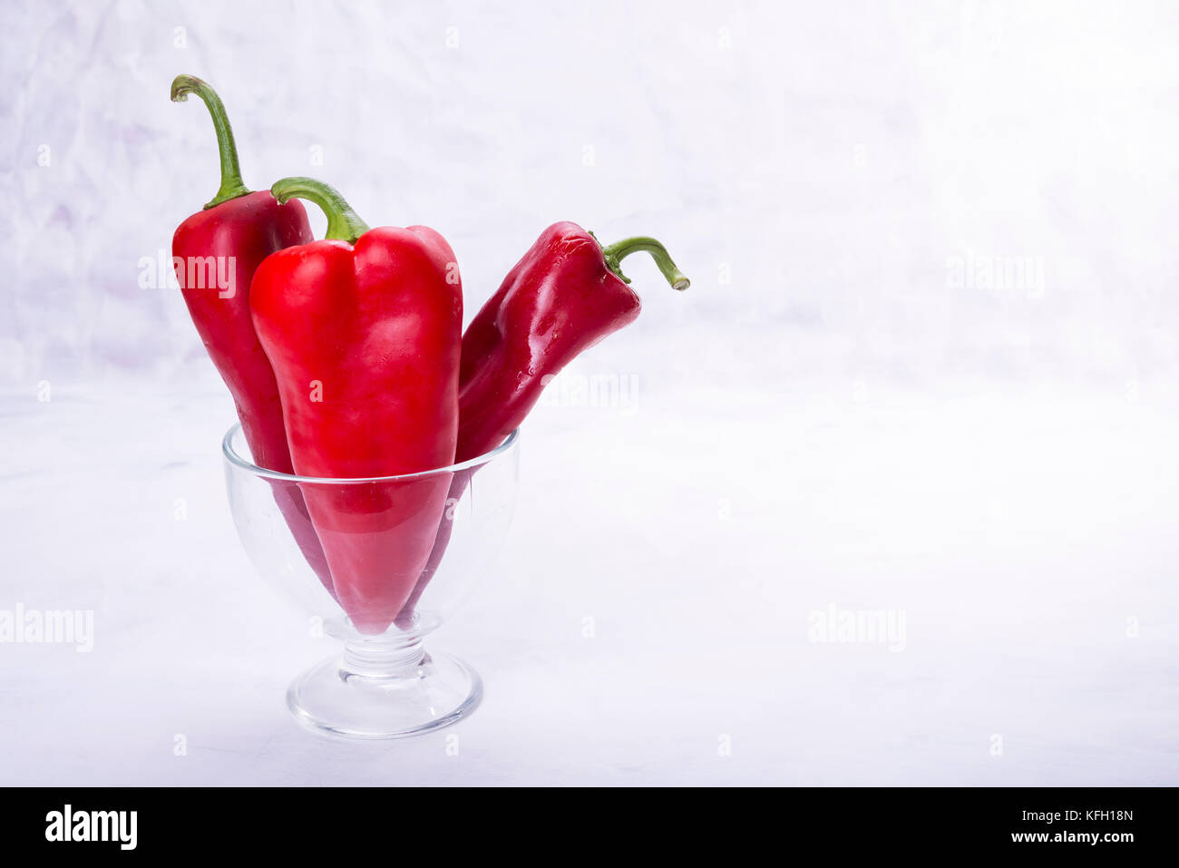 Three red peppers as vegetable inserted in the glass Stock Photo - Alamy