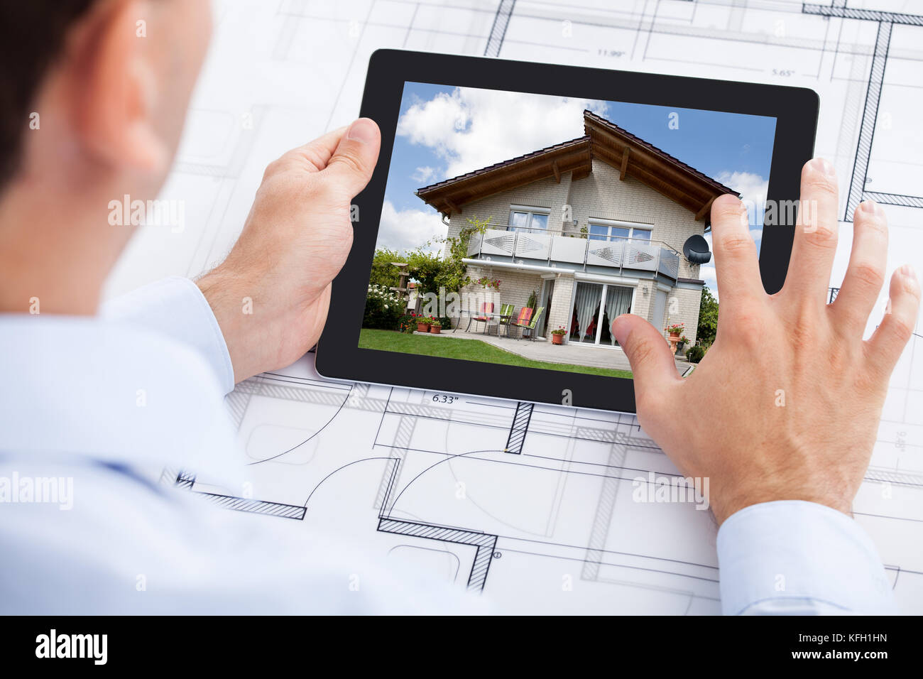 Cropped image of architect analyzing house on digital tablet over ...