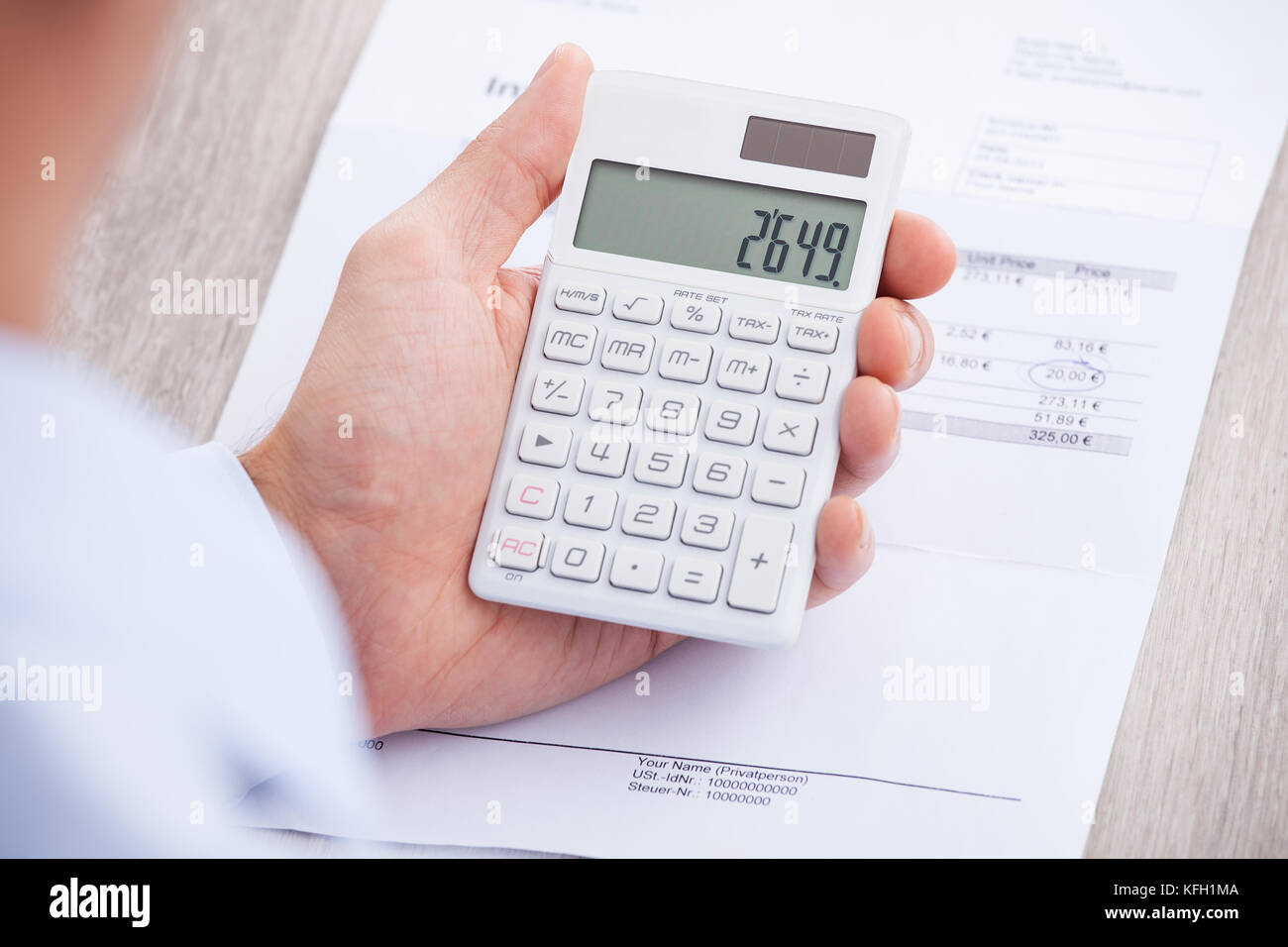 Cropped image of businessman's hands calculating invoice at desk Stock ...