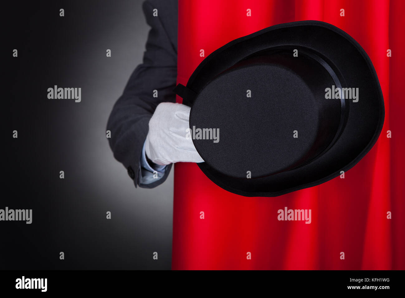 Cropped image of magician holding hat behind stage curtain Stock Photo ...