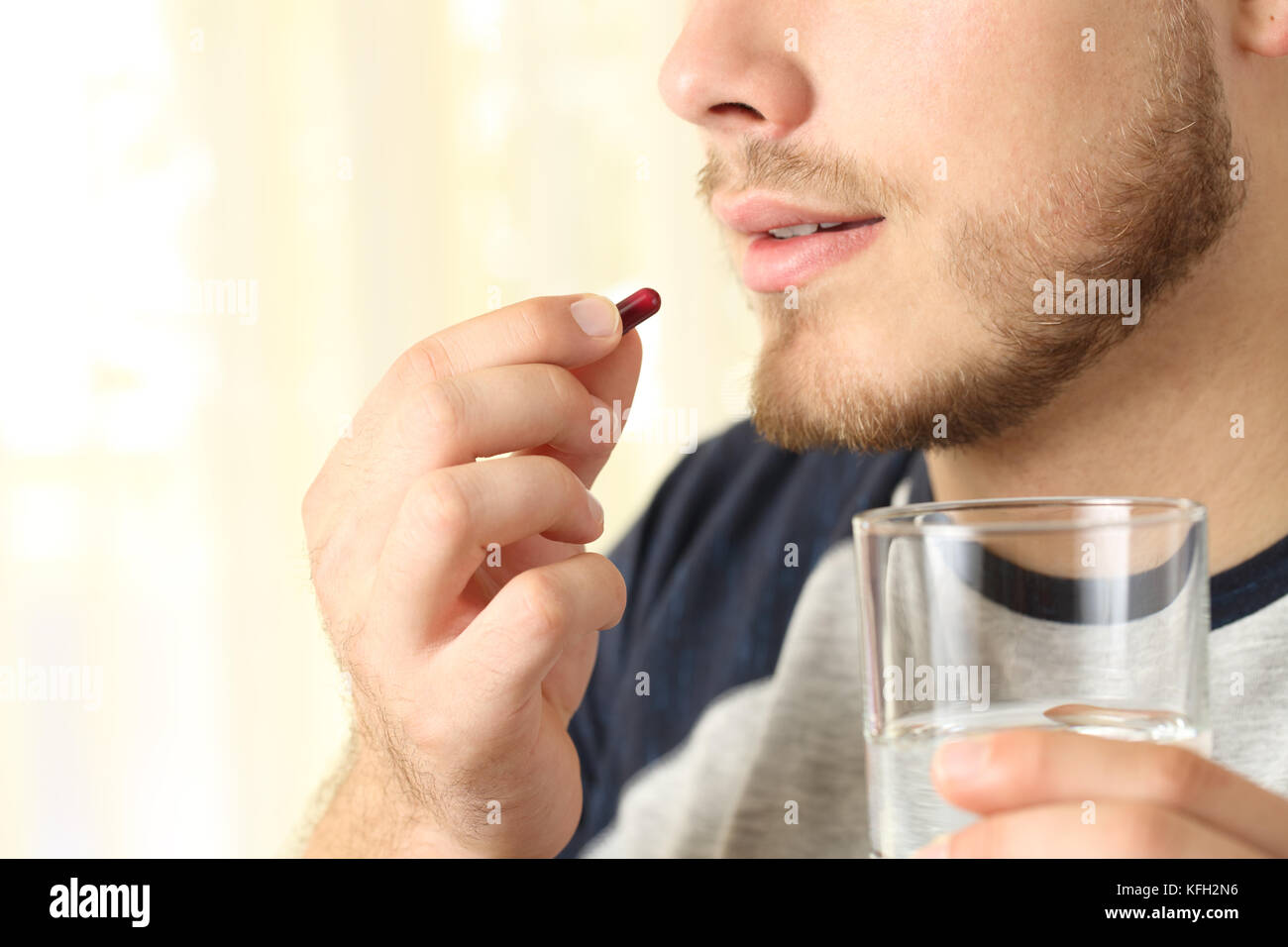 Close up of a man ready to swallow a pill Stock Photo - Alamy