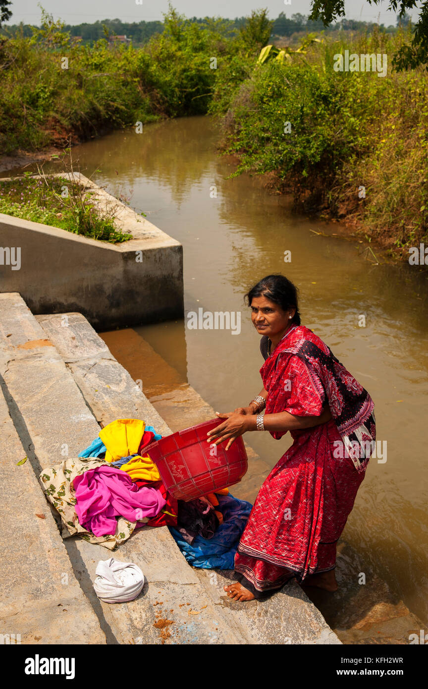 Indian Woman Washing Clothes On A Small River In The Rural Karnataka