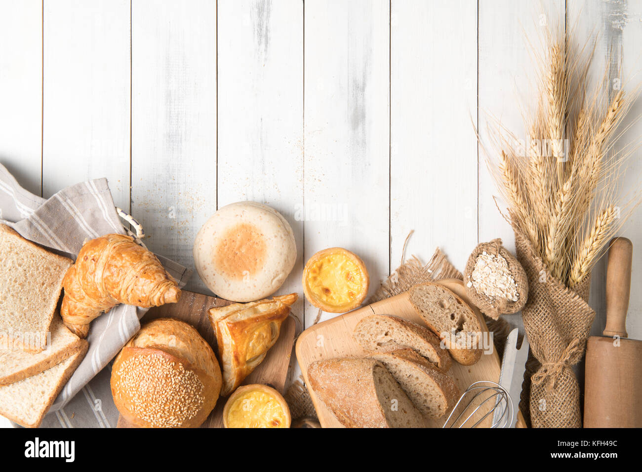 bread and bakery ingredients on white wooden background, top view and ...