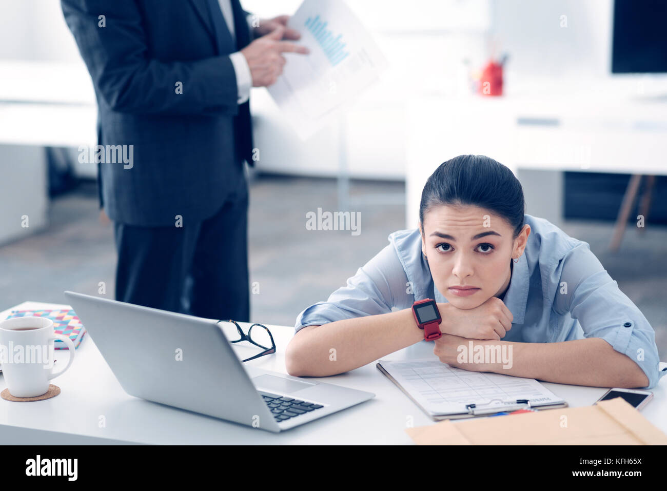 Exhausted female employee looking upset at work Stock Photo - Alamy