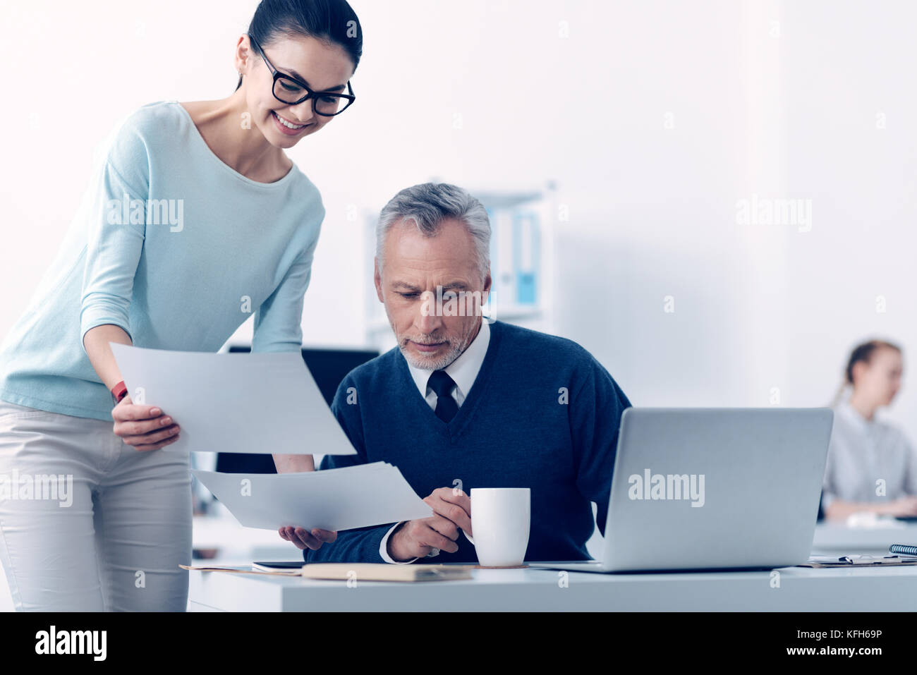 Two business colleagues comparing documents at work Stock Photo - Alamy