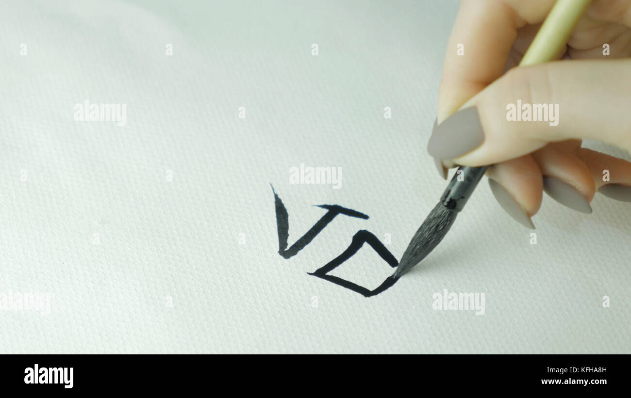 Woman's hands writing Chinese hieroglyph. Female hand holding a writing ...