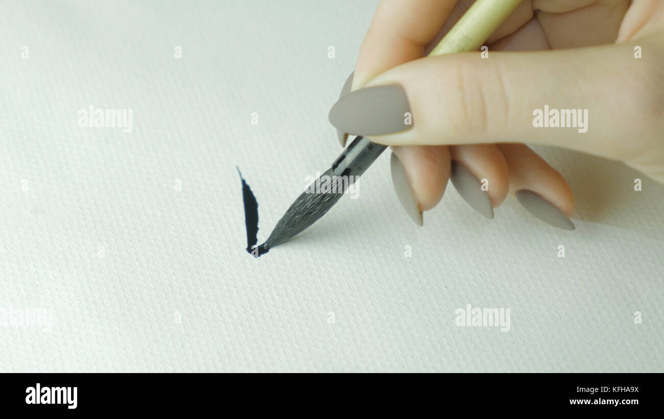 Woman's hands writing Chinese hieroglyph. Female hand holding a writing ...