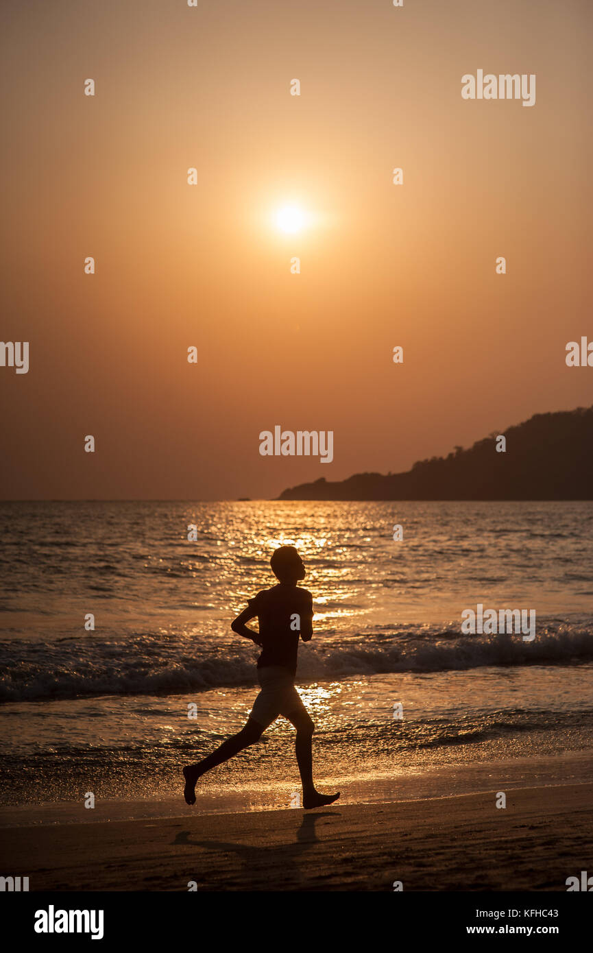 Running on the beach at sunset Stock Photo - Alamy
