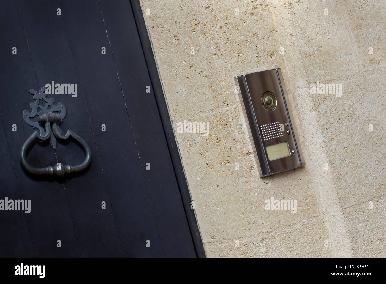 Modern intercom and classic door knocker on the facade of a French ...