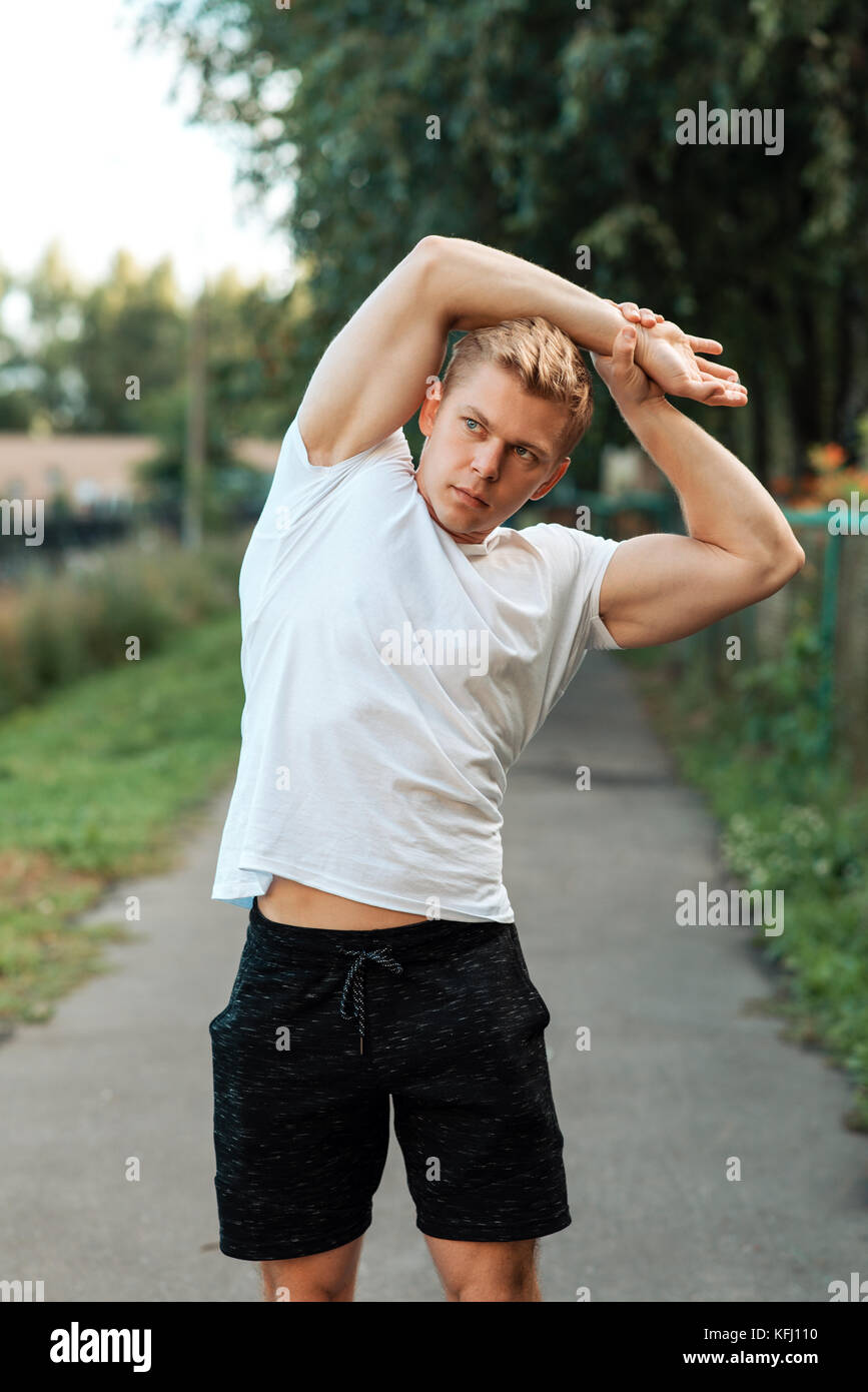 Male athlete warm-up in nature, street in the city, warming up the ...