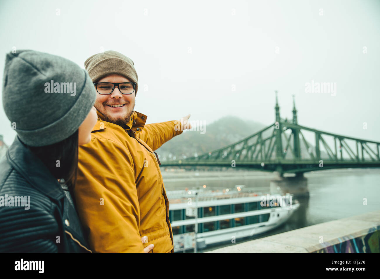 man pointing while standing near river in foggy morning bridge on ...