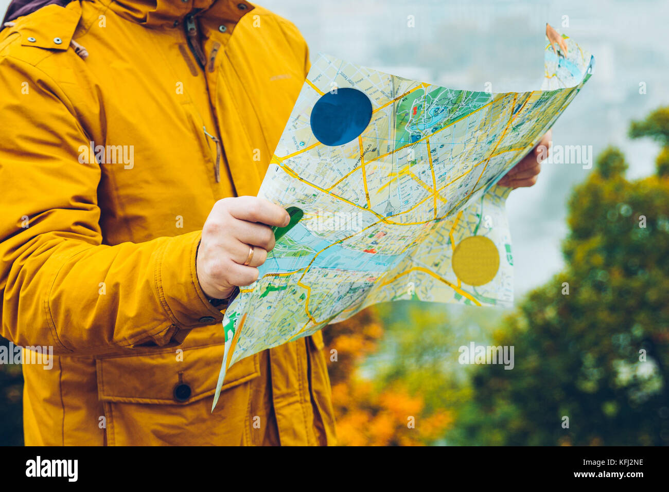 young man holding map in hands in autumn day european city on ...