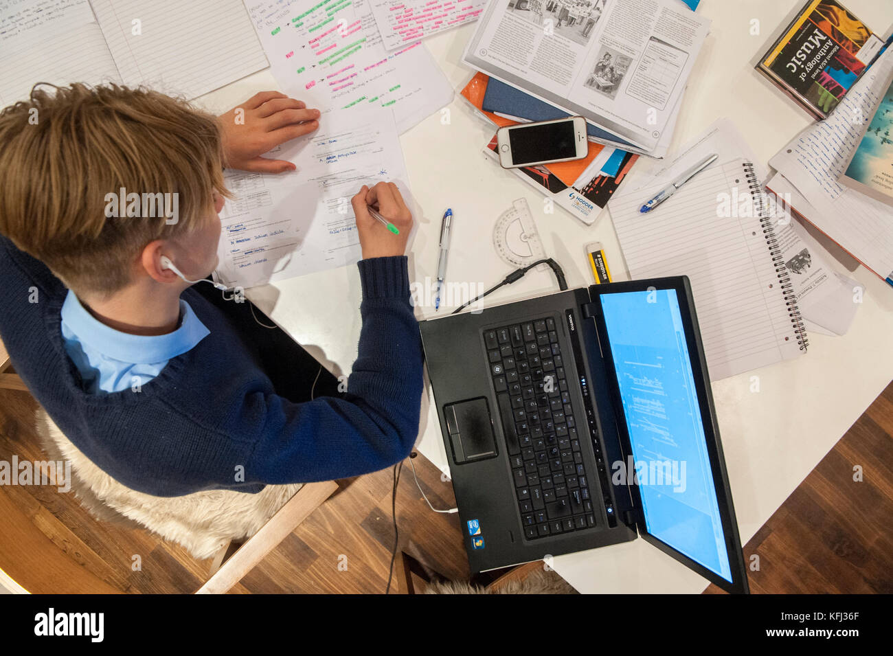 A young boy does his homework at the kitchen table in preparation for ...