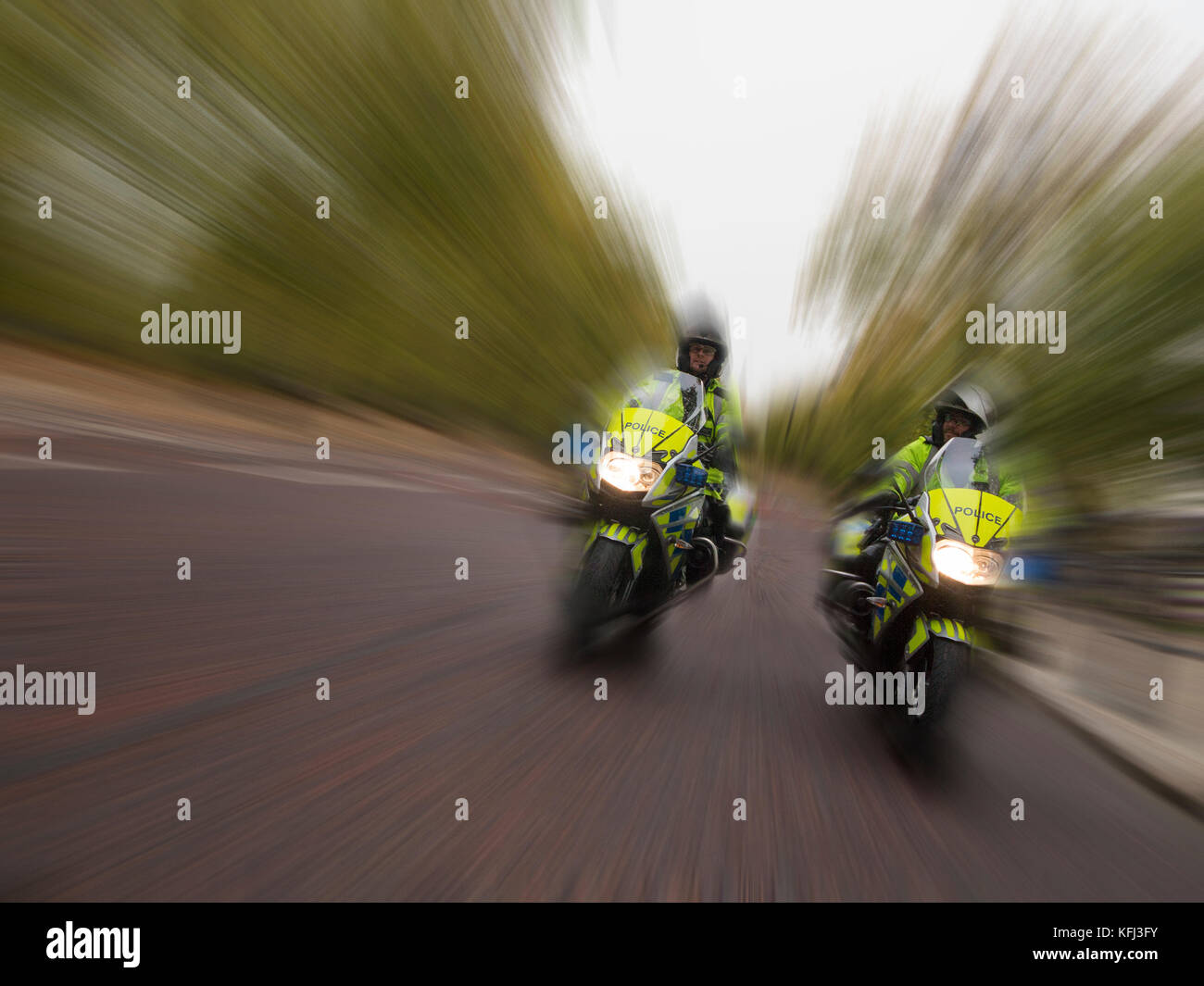 Two police motorbikes race towards the camera at speed, with a blurred ...