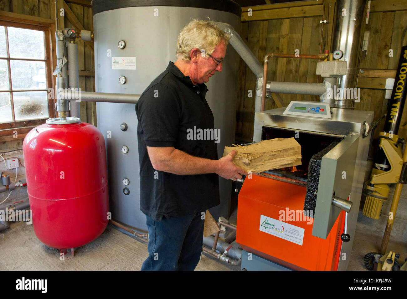 Chris Chilcott with his wood burning boiler at his home in Cornwall ...