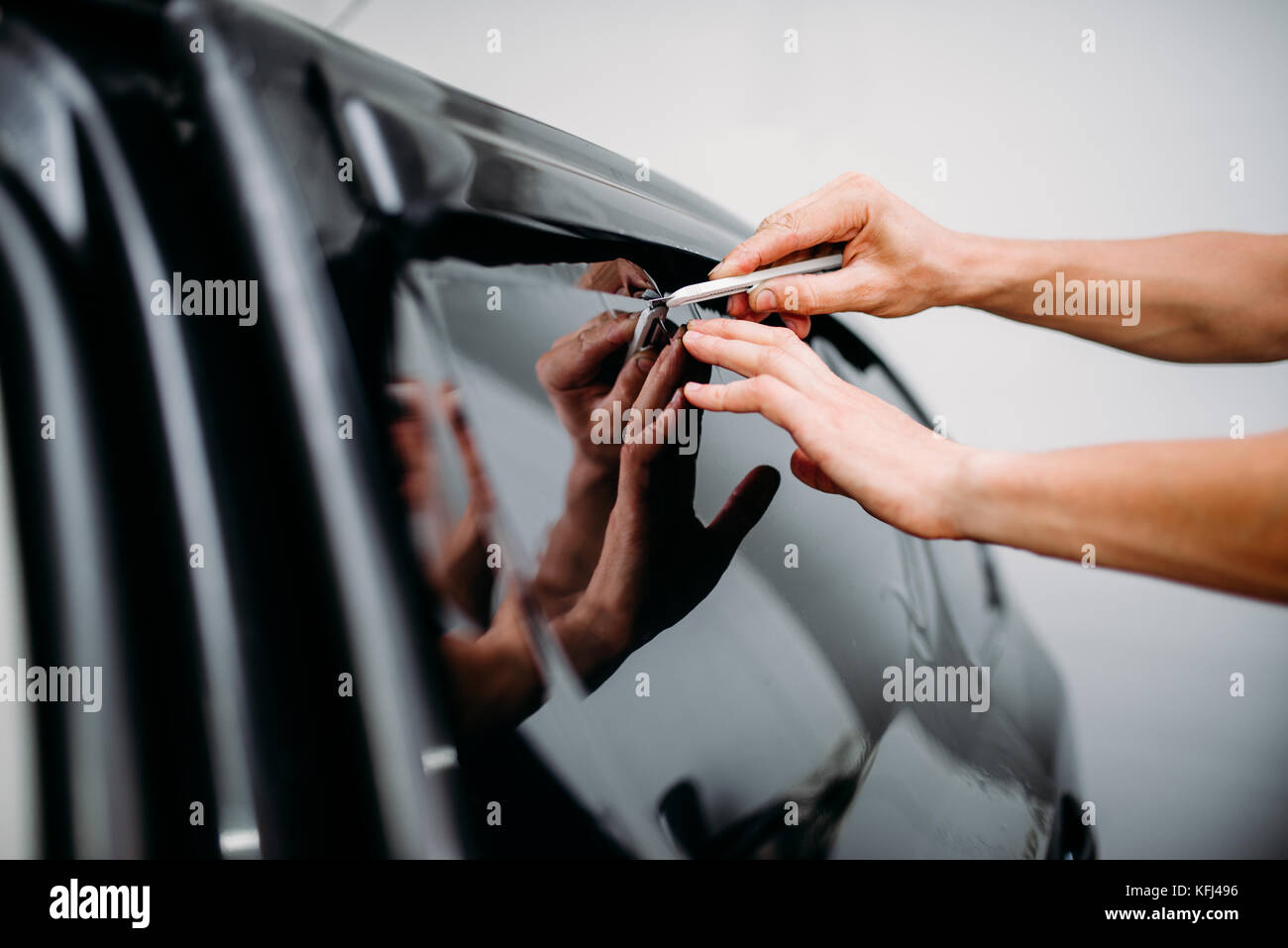 Male specialist work with car, tinting film installation process ...