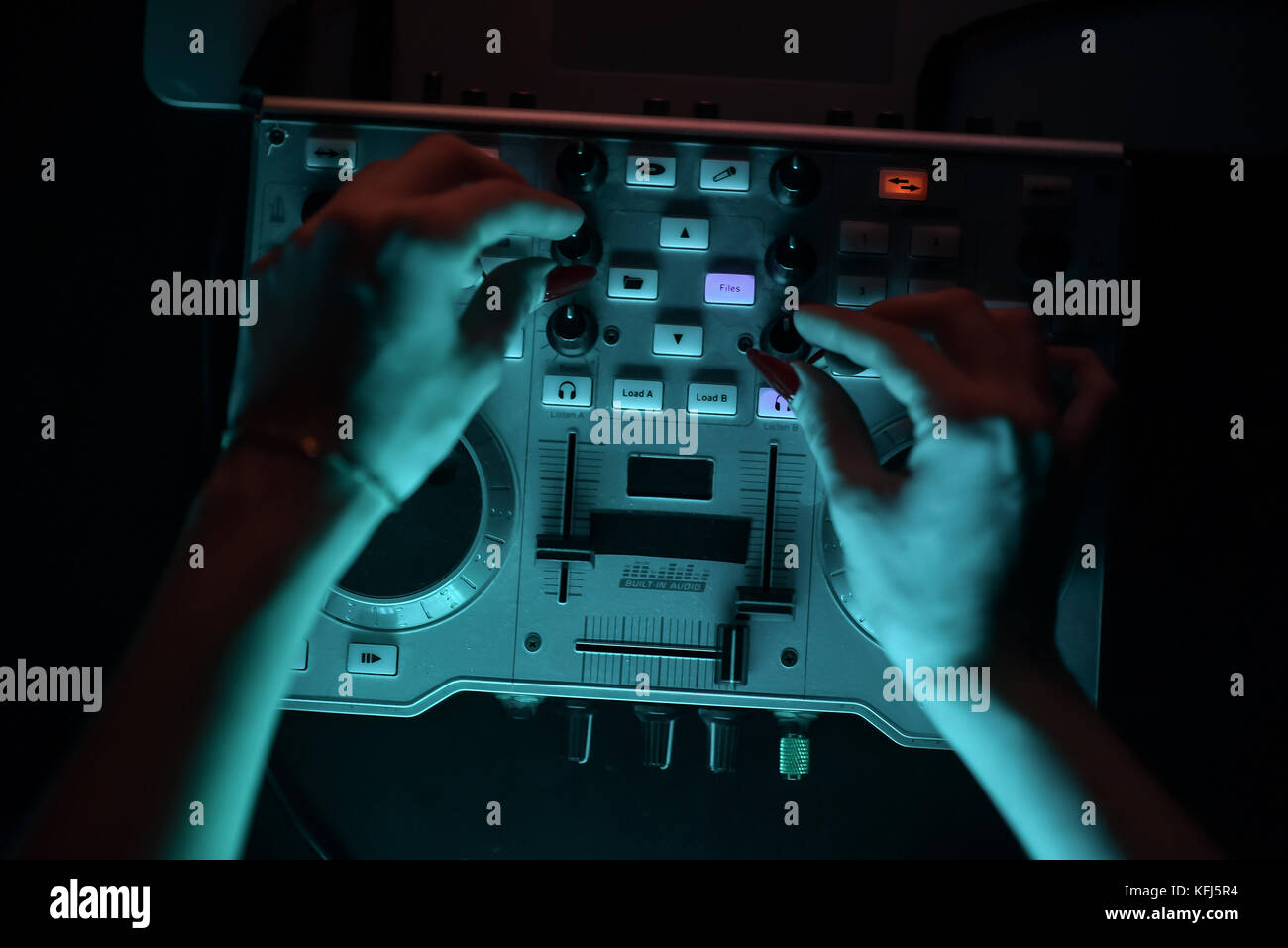 DJ mixer disco illuminated by searchlights Stock Photo - Alamy