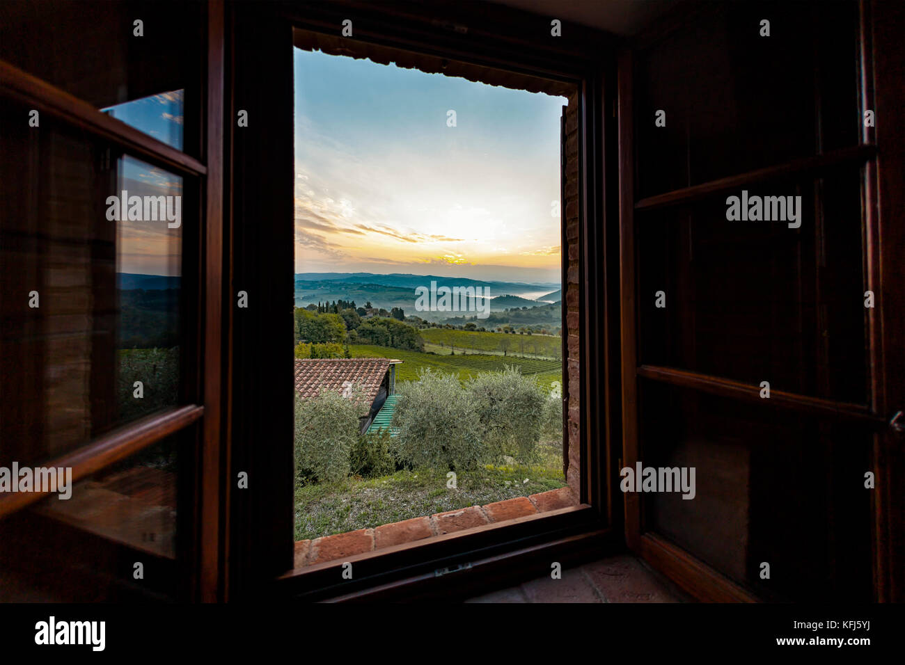 View through a window of apartment in Tuscany to a sunrise over foggy ...