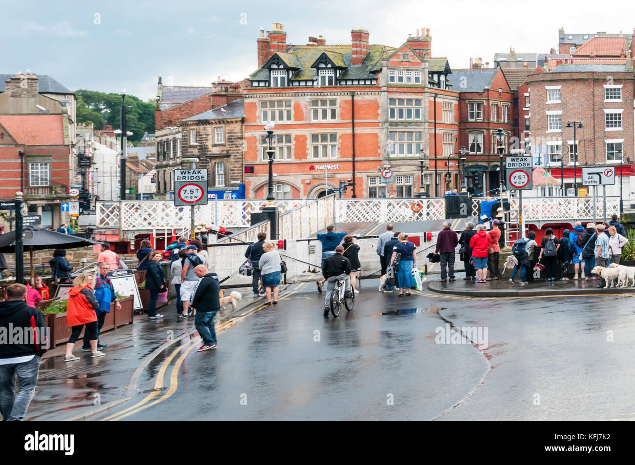 Pedestrians waiting for the swing bridge across Whitby harbour to open ...