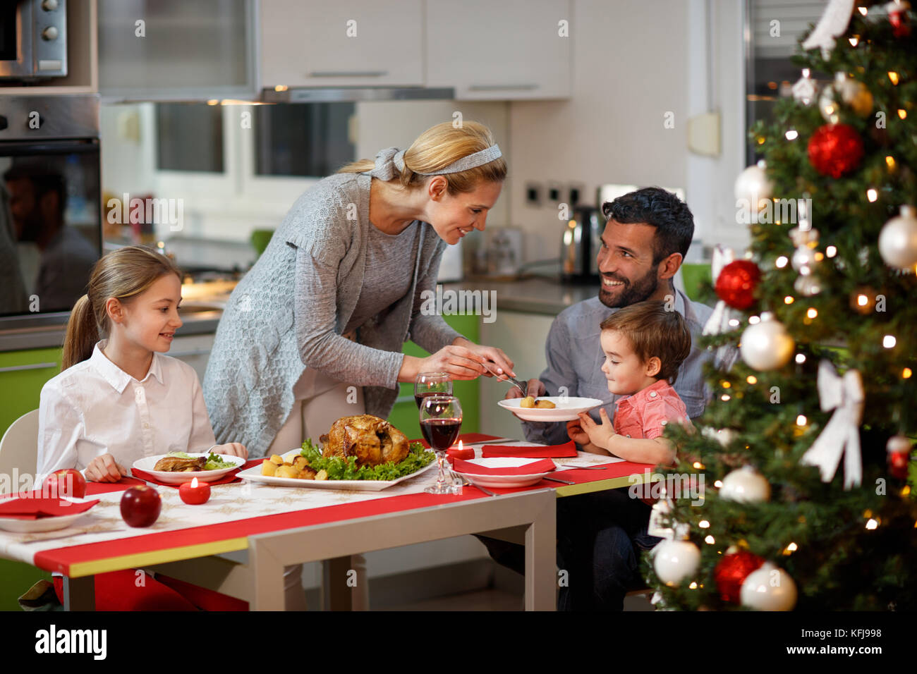 Family together at decorated table having festively Christmas dinner ...