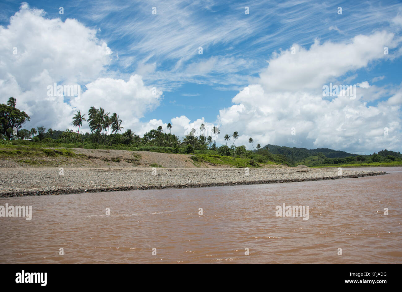Lush tropical greenery along the Navua River under a blue sky with ...