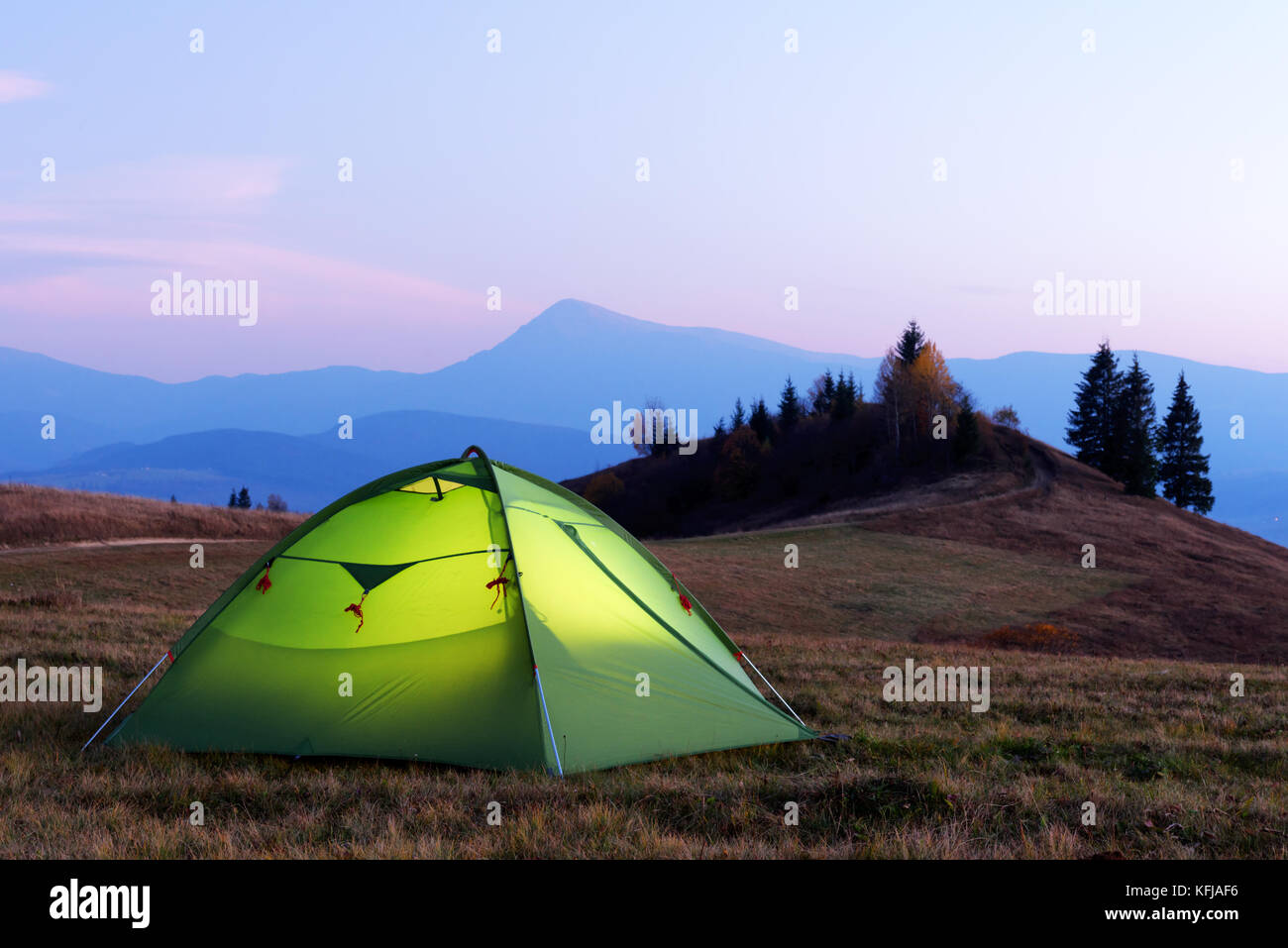 Green tent lighted from the inside Stock Photo - Alamy