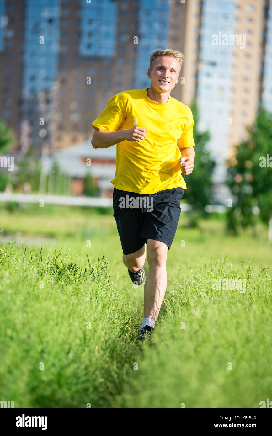 Sporty man jogging in city street park. Outdoor fitness Stock Photo - Alamy