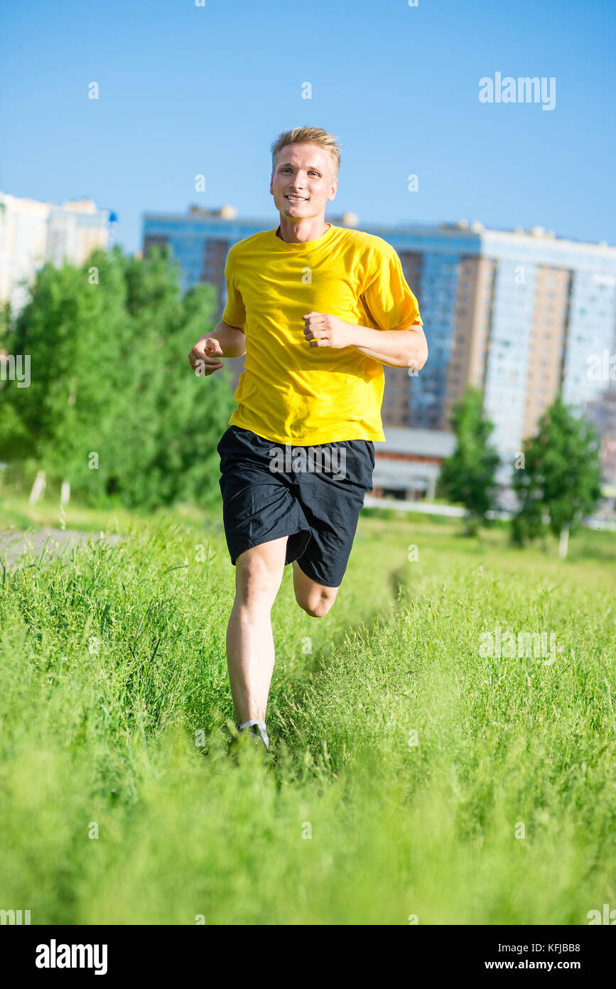 Sporty man jogging in city street park. Outdoor fitness Stock Photo - Alamy